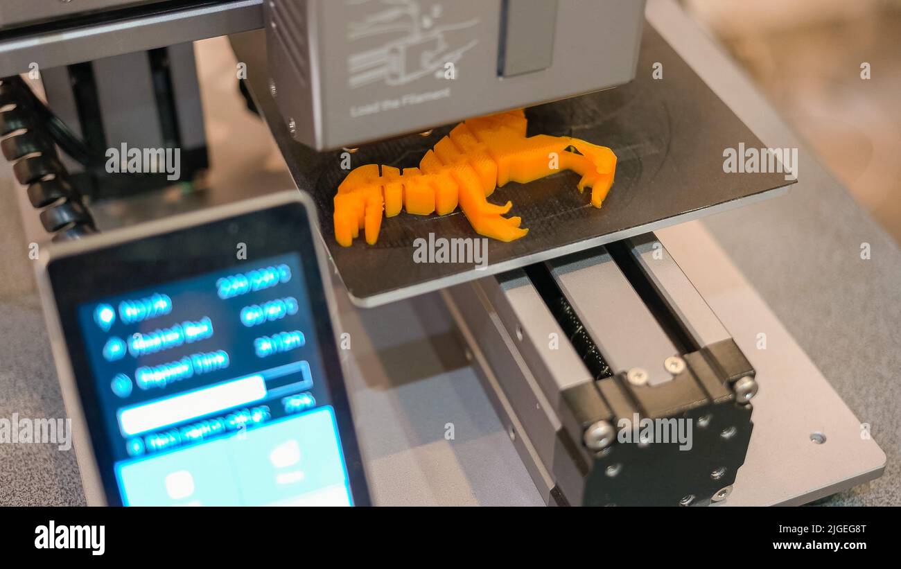 Top view fast speed motion 3d printer is making a yellow figure ...