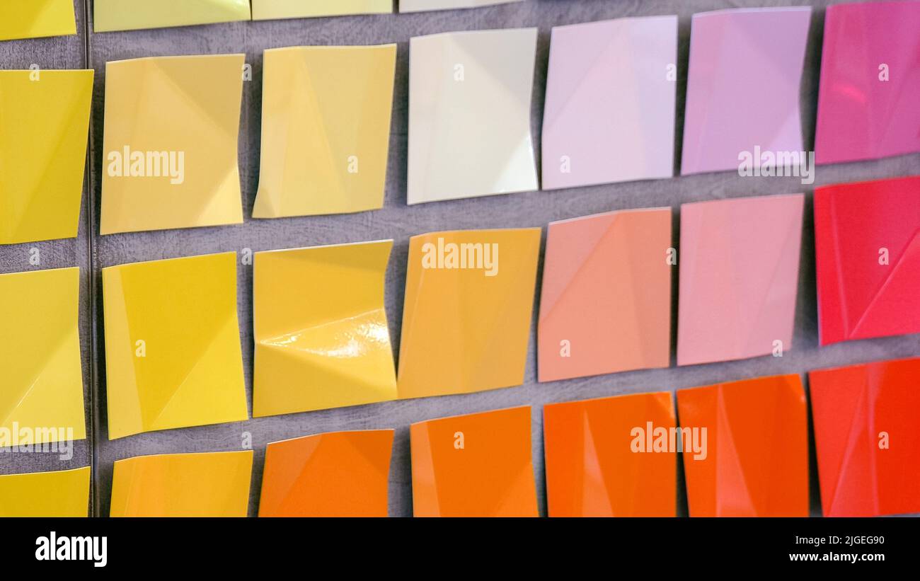 Wall with hanging colored square metal pieces of the same size ...
