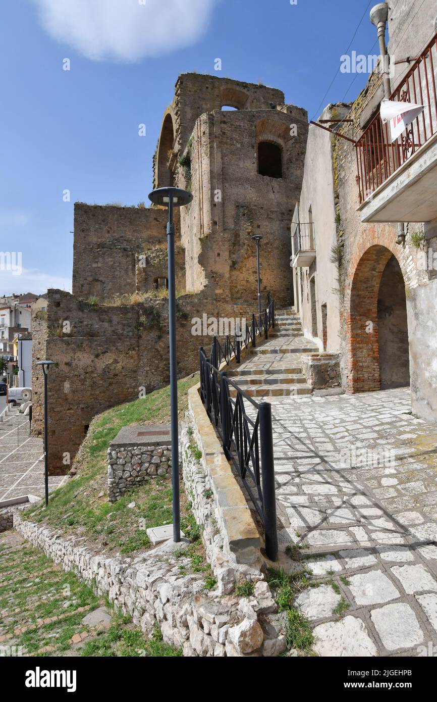 A narrow street between the old houses of Grottole, a village in the ...