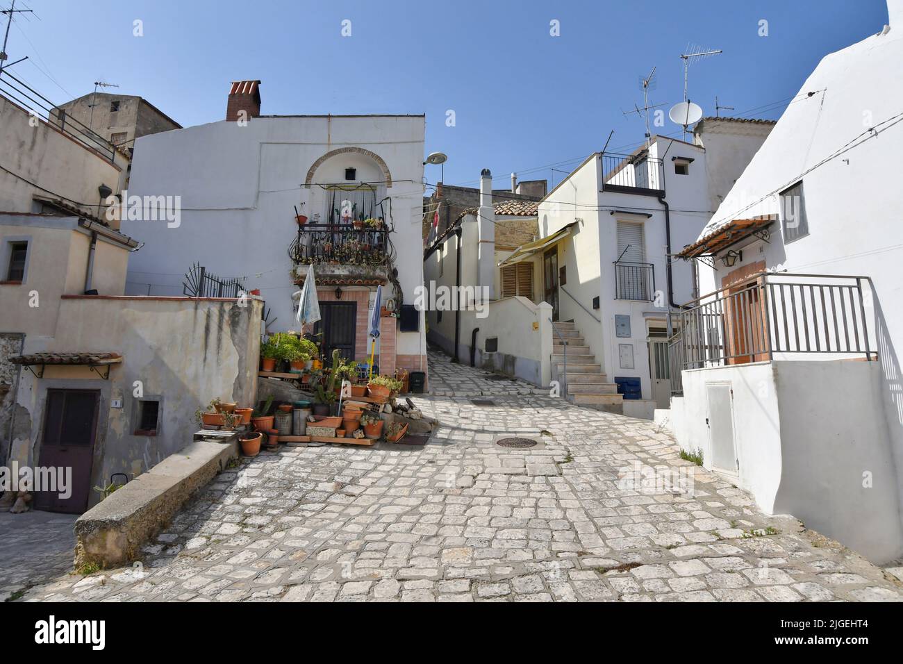 A narrow street between the old houses of Grottole, a village in the ...
