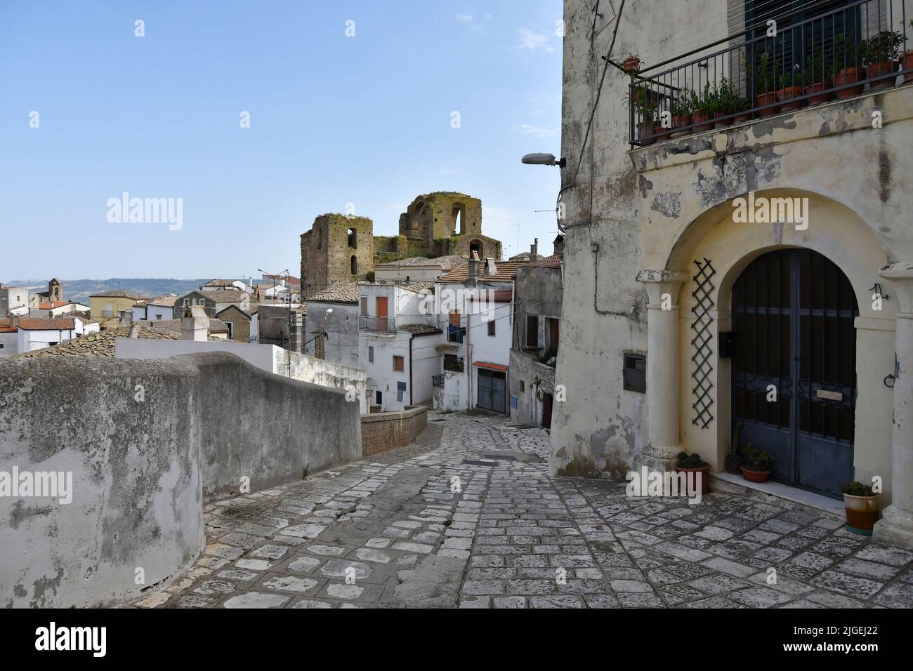 A narrow street between the old houses of Grottole, a village in the ...