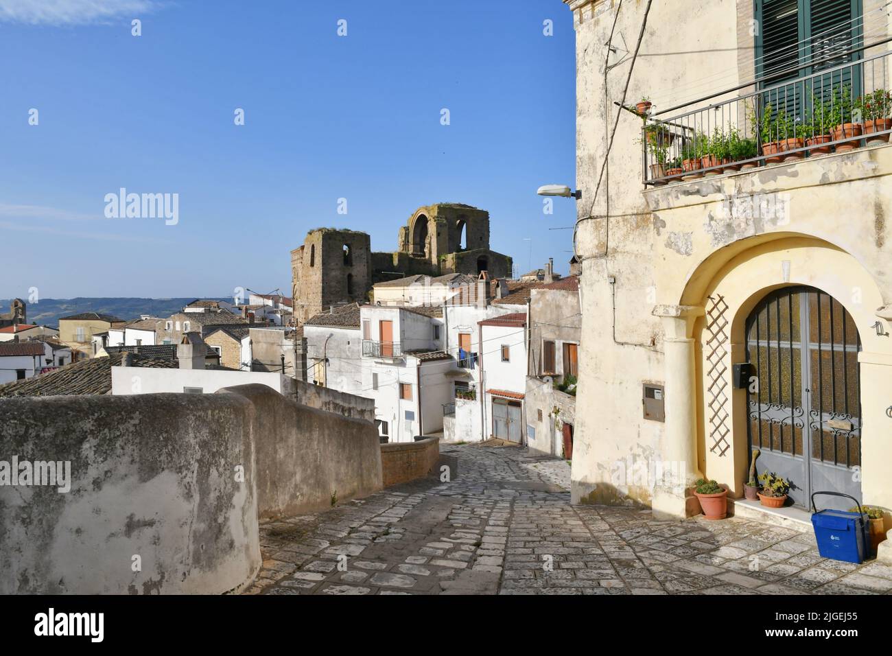 A narrow street between the old houses of Grottole, a village in the ...