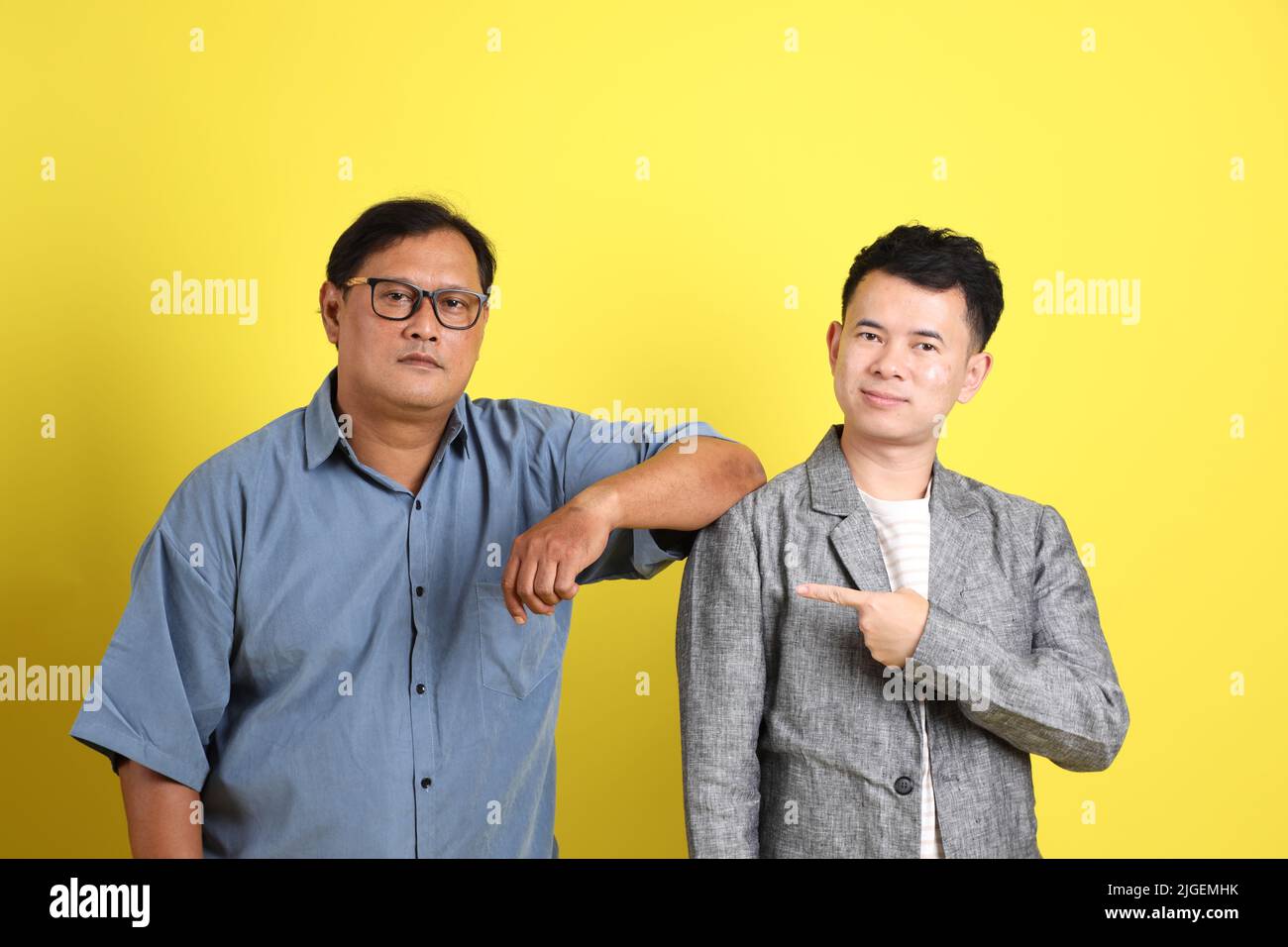 The adult two people standing on the yellow background Stock Photo - Alamy