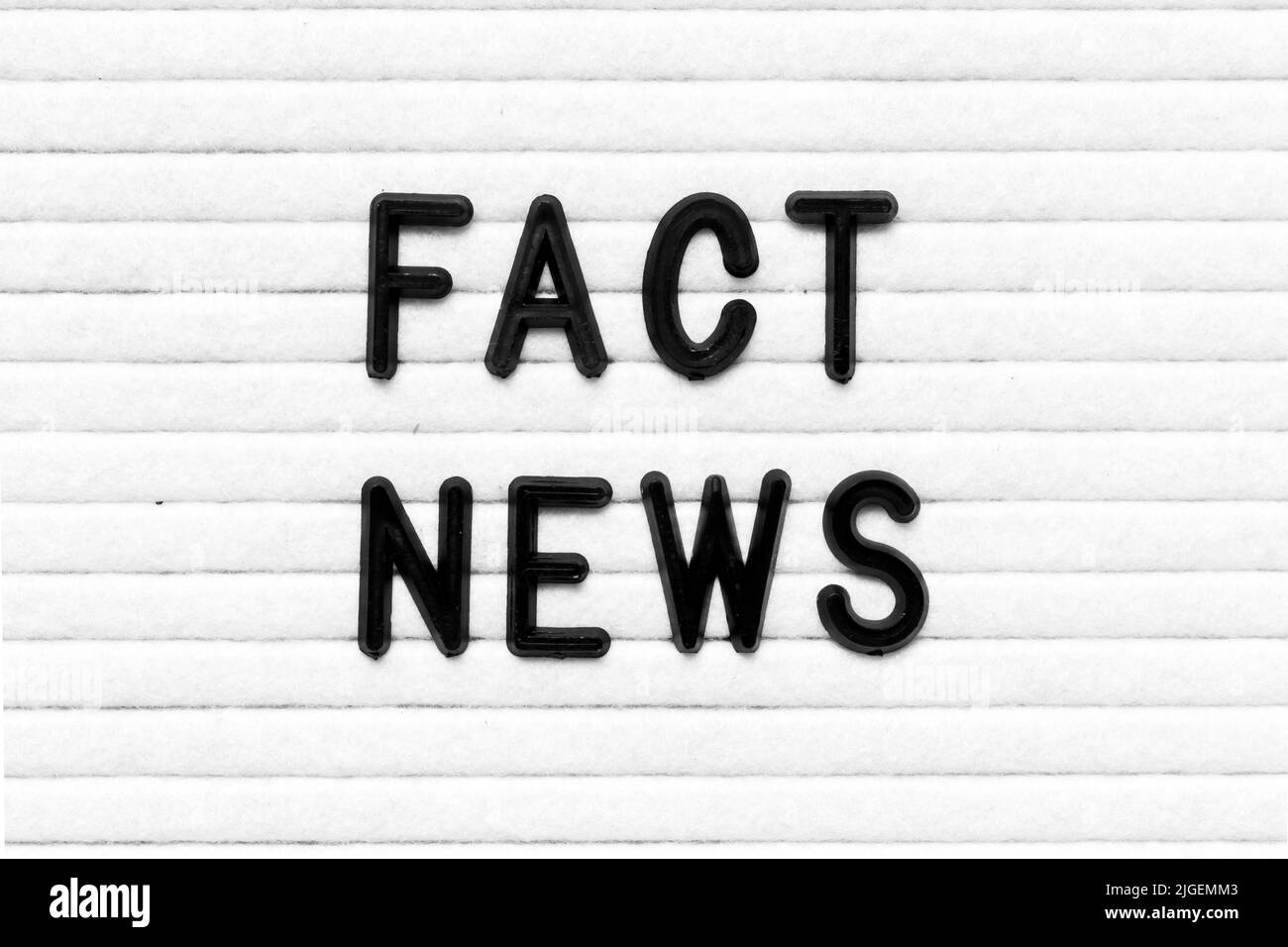 Black color letter in word fact news on white felt board background ...