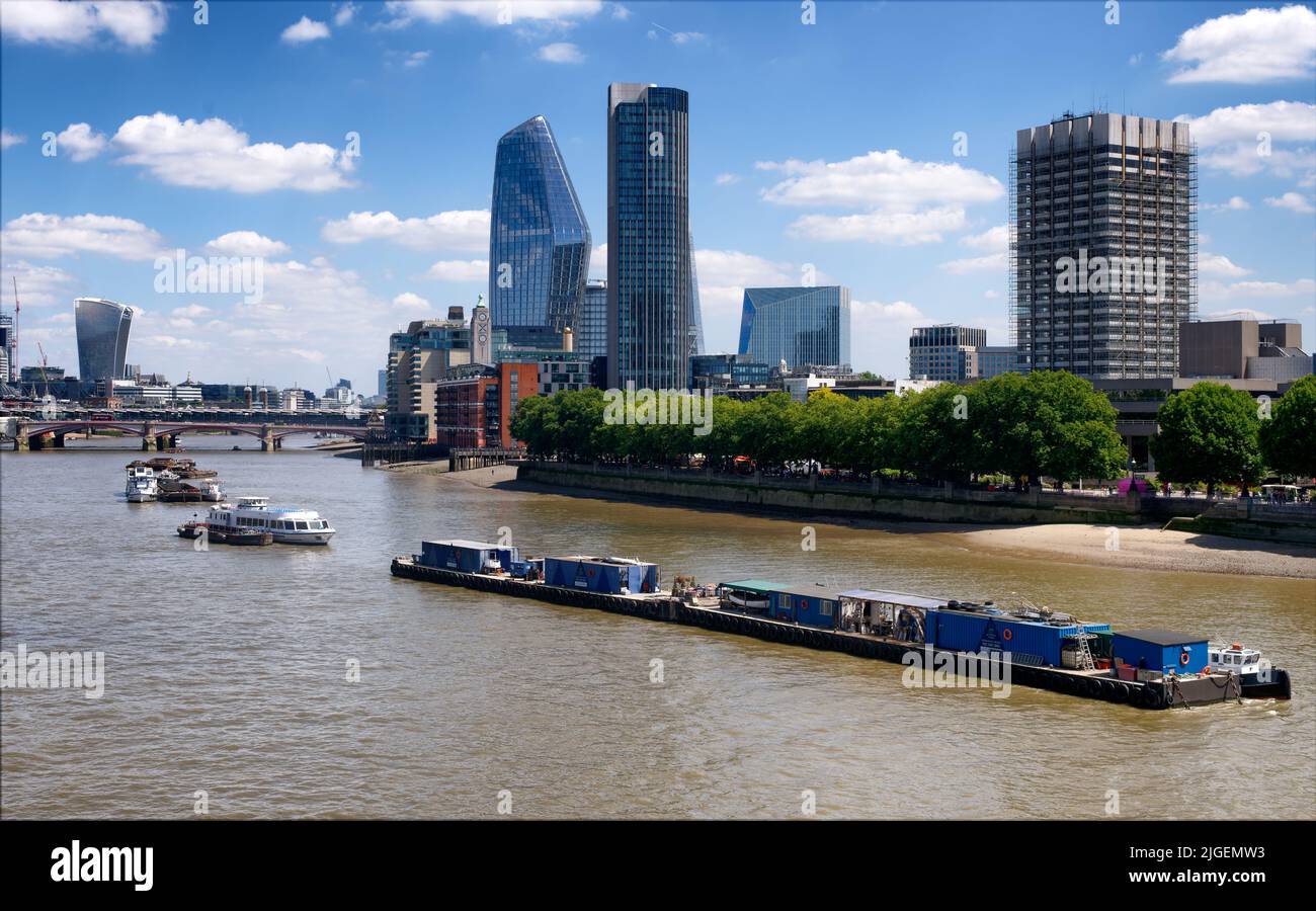Boats moored on a floating pontoon dock along the River THames with the ...