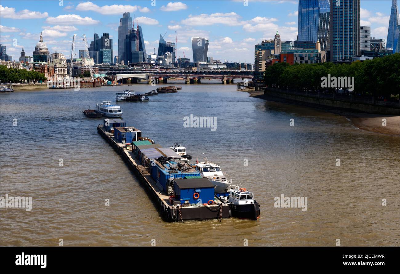 Boats moored on a floating pontoon dock along the River THames with the ...