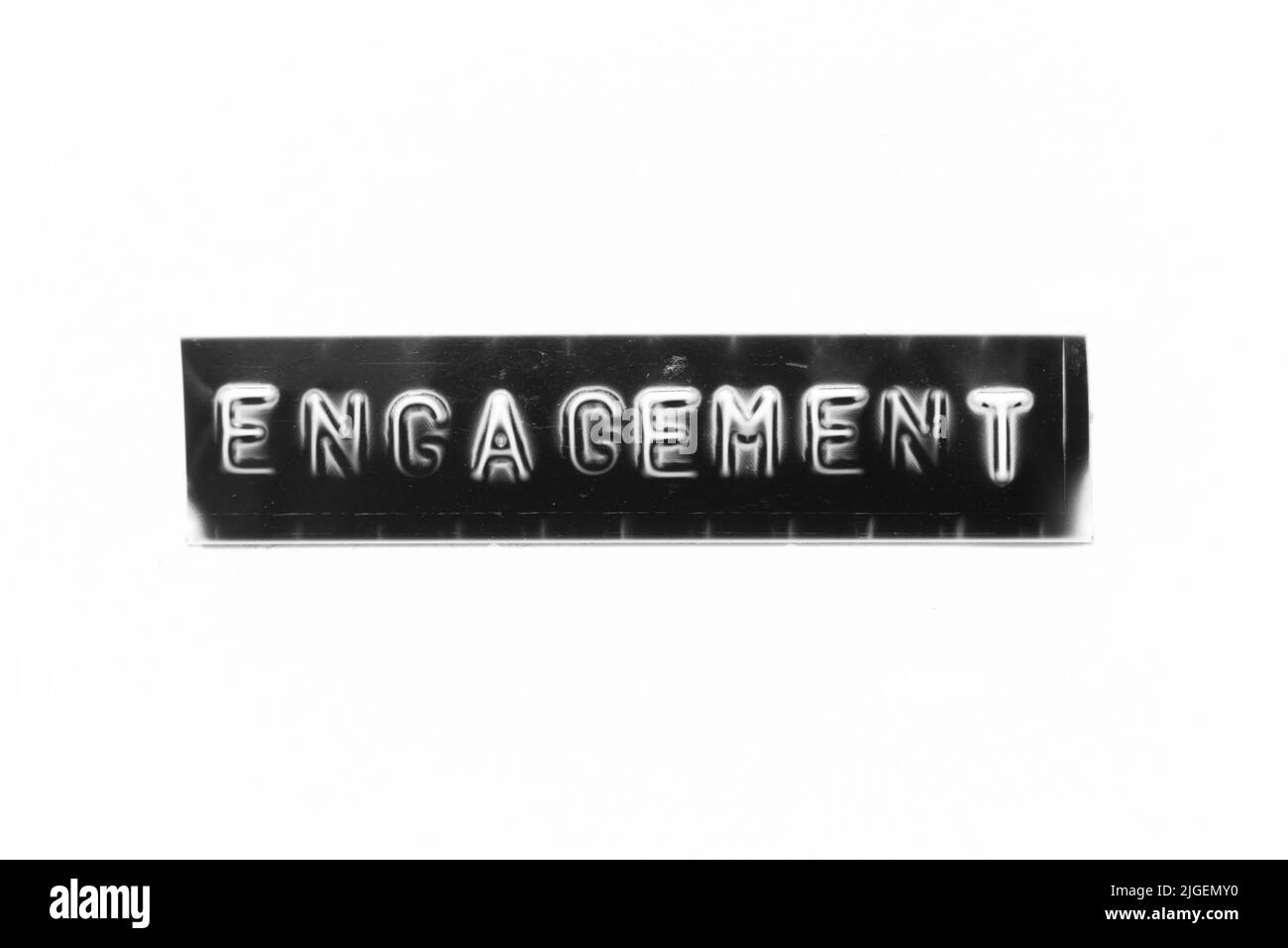 Embossed letter with word engagement in black banner on white paper ...