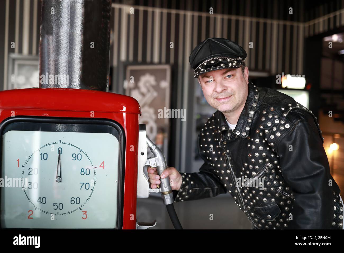 Happy man holding refueling gun in garage Stock Photo - Alamy