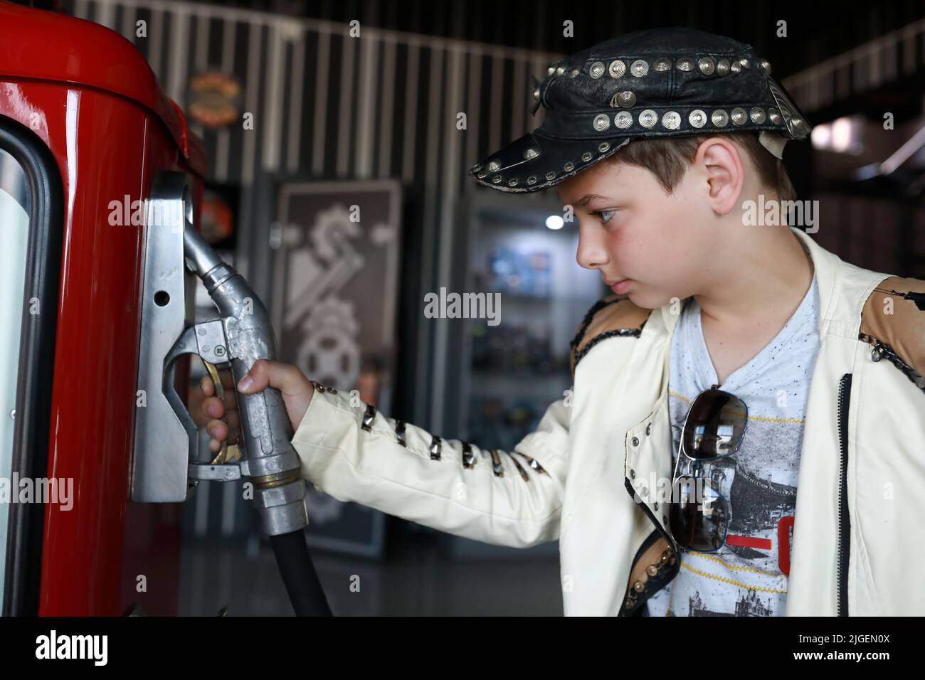 Portrait of boy holding refueling gun in garage Stock Photo - Alamy