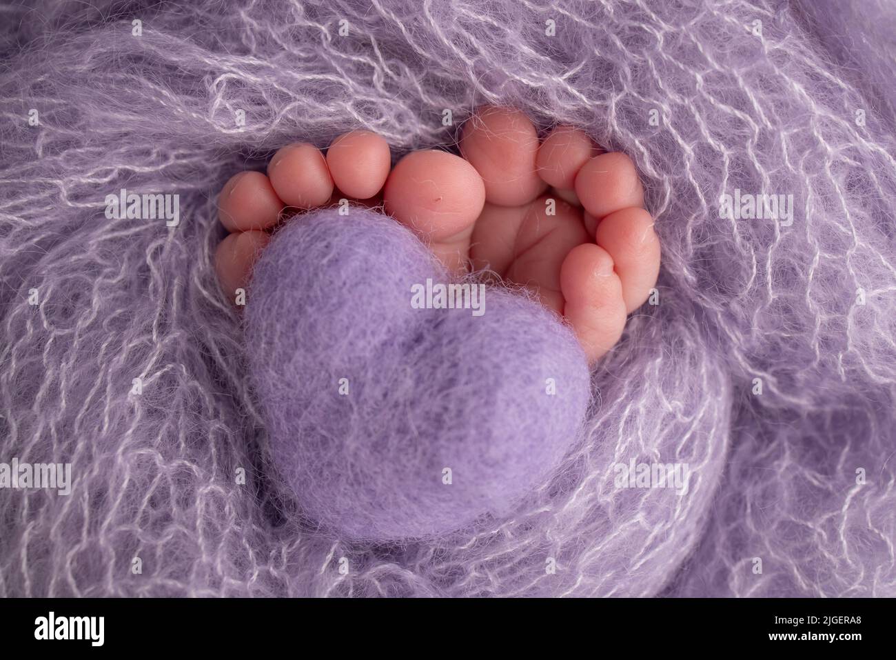 The tiny foot of a newborn baby. Soft feet of a new born. Knitted ...