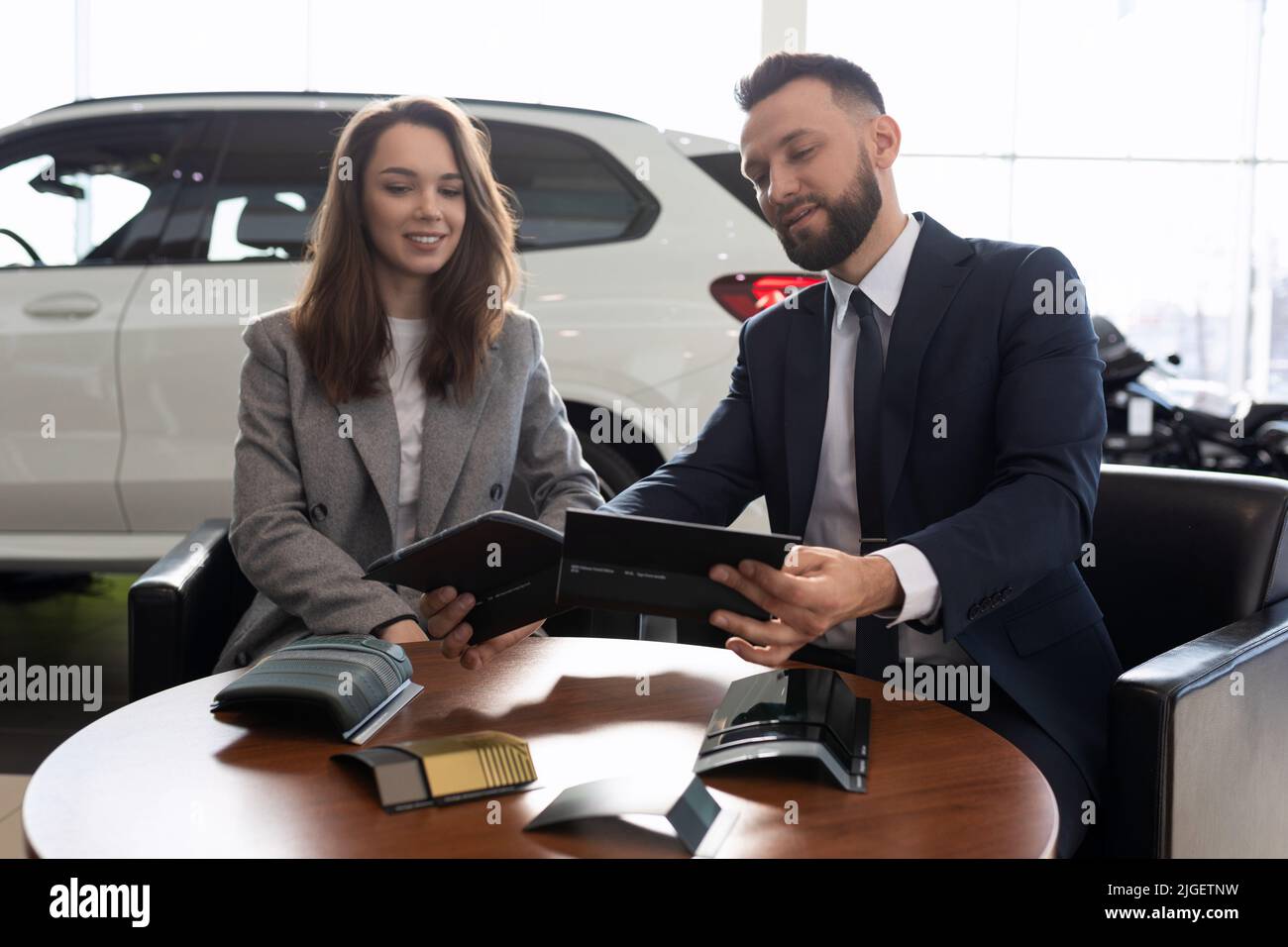 a car dealership employee helps to choose interior trim materials for a ...