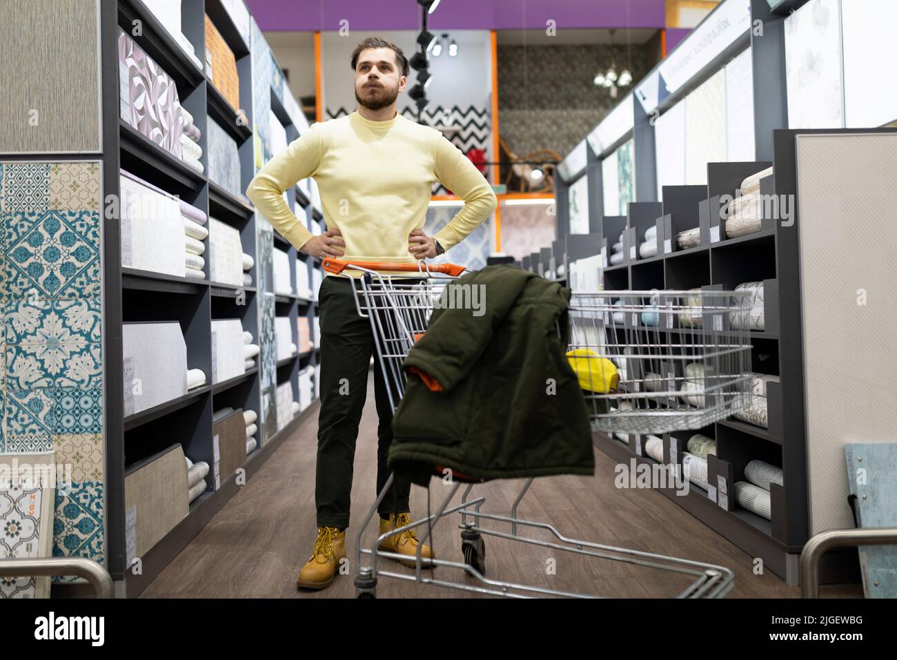 a customer in a hardware store next to a grocery cart getting ready to ...