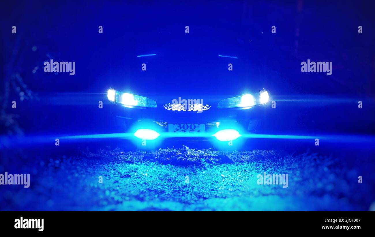 The illuminated blue headlights on a car Stock Photo - Alamy