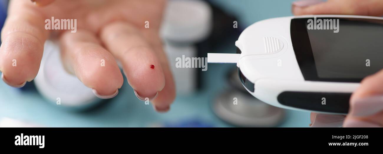 Doctor check blood sugar level of client use digital glucometer at ...