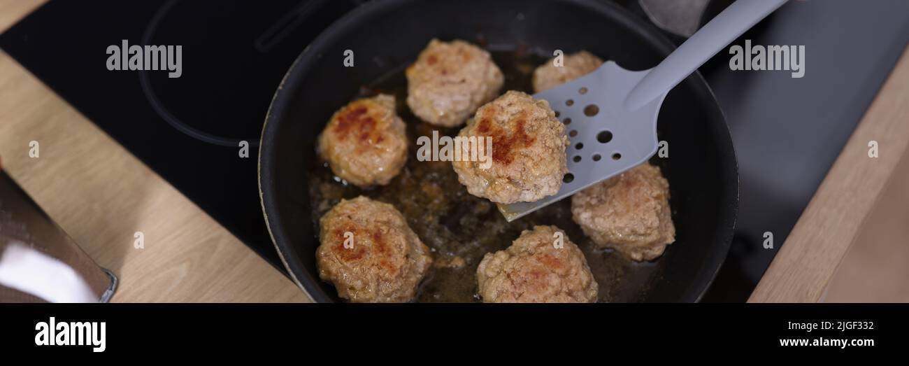 Meat balls beginning to fry in oil in frying pan on kitchen stove Stock ...