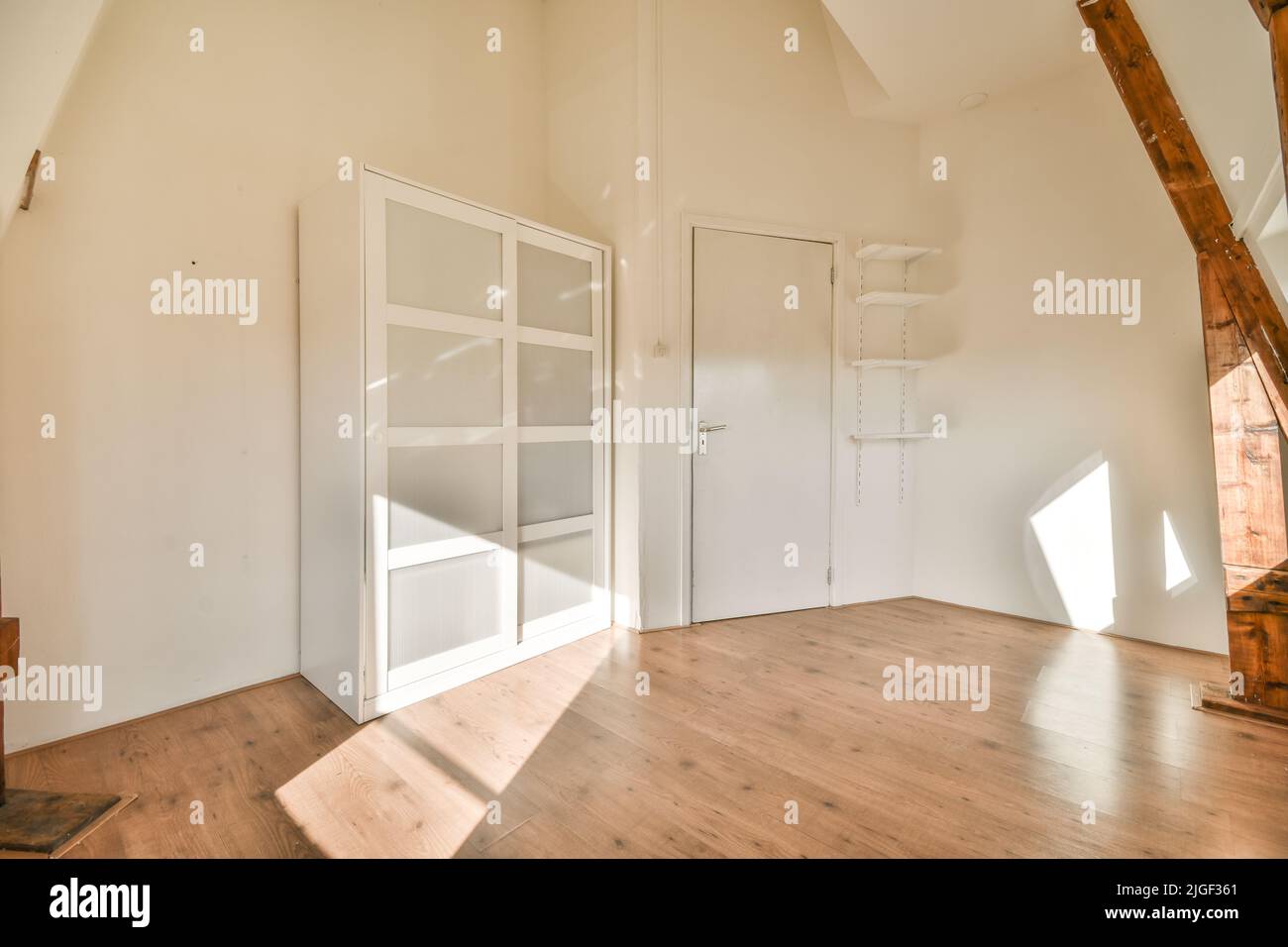 Modern cupboard near doors and wicker basket in spacious room with ...