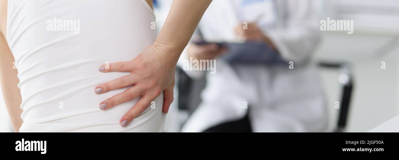 Female patient complain on back pain and touch side of body Stock Photo ...