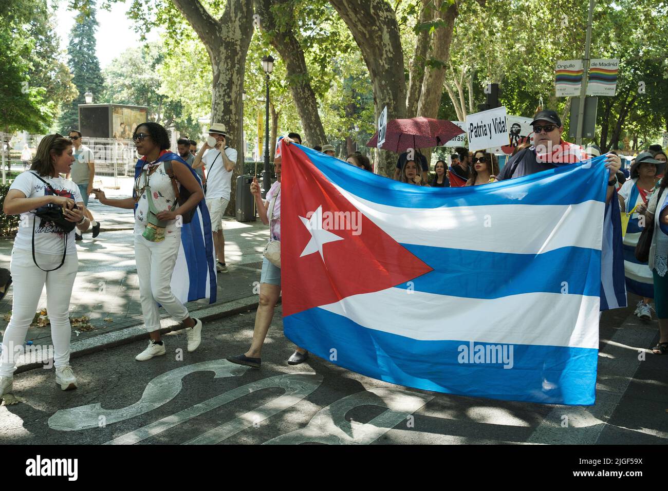 Protesters march while holding a Cuban flag during the demonstration to ...