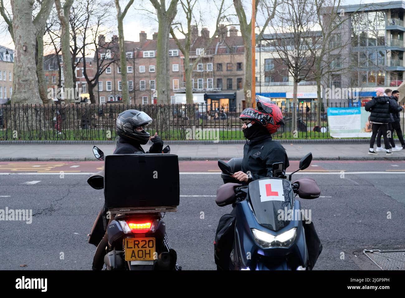 Delivery drivers chat on Upper Street in London's Islington Stock Photo ...