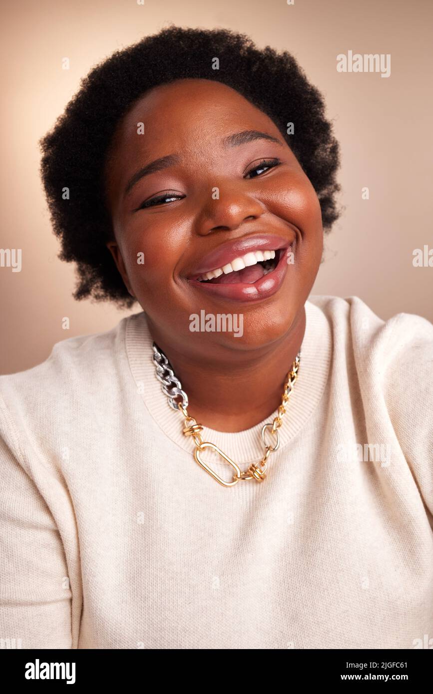 It must be her smile. Studio shot of a beautiful young woman posing ...