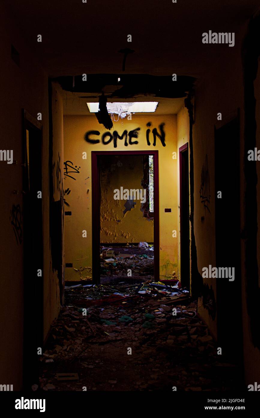 An old creepy door hallway with a "come in" text on the door Stock ...