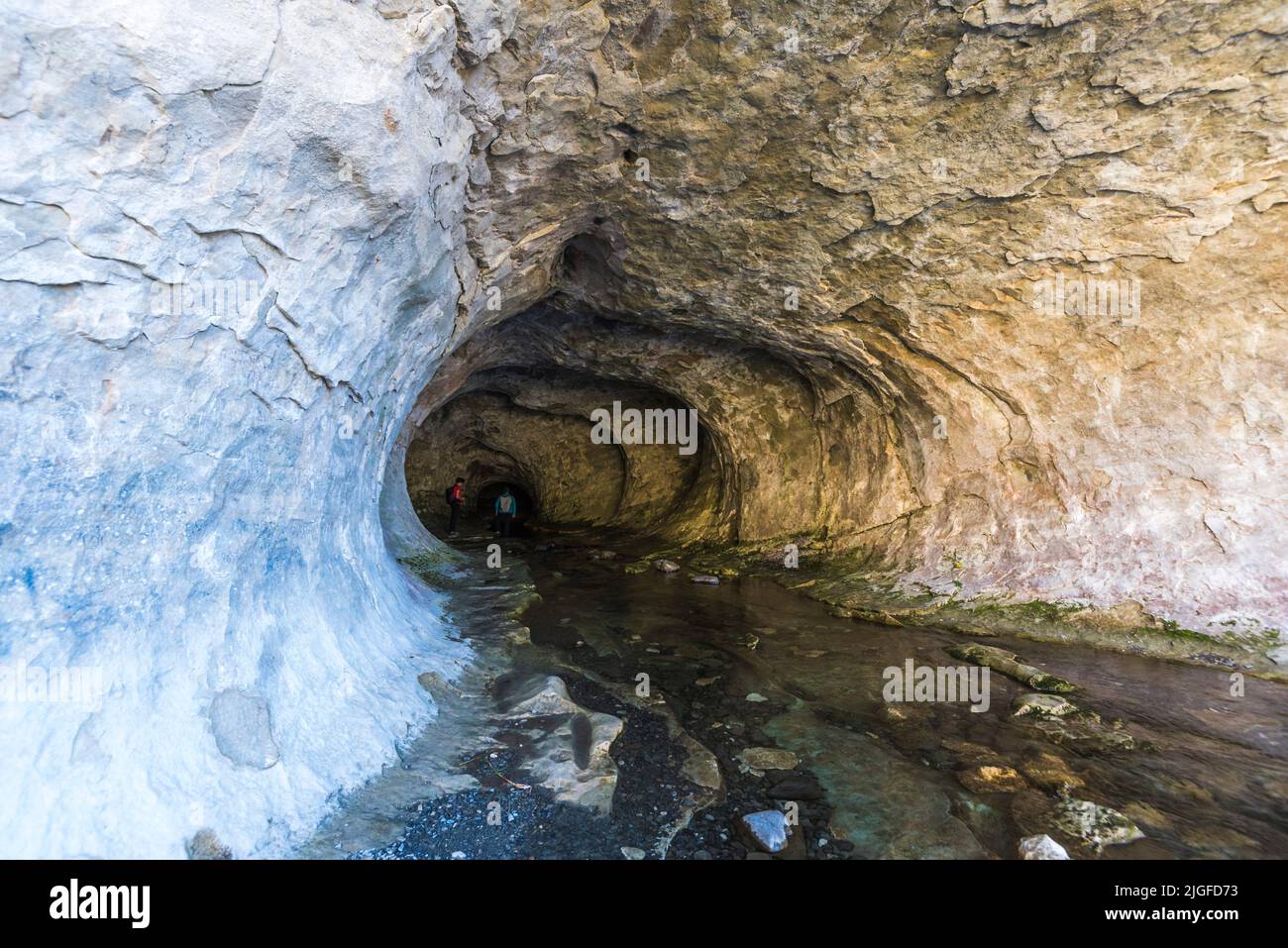 Inside the cave with a small water stream flowing through it in New ...