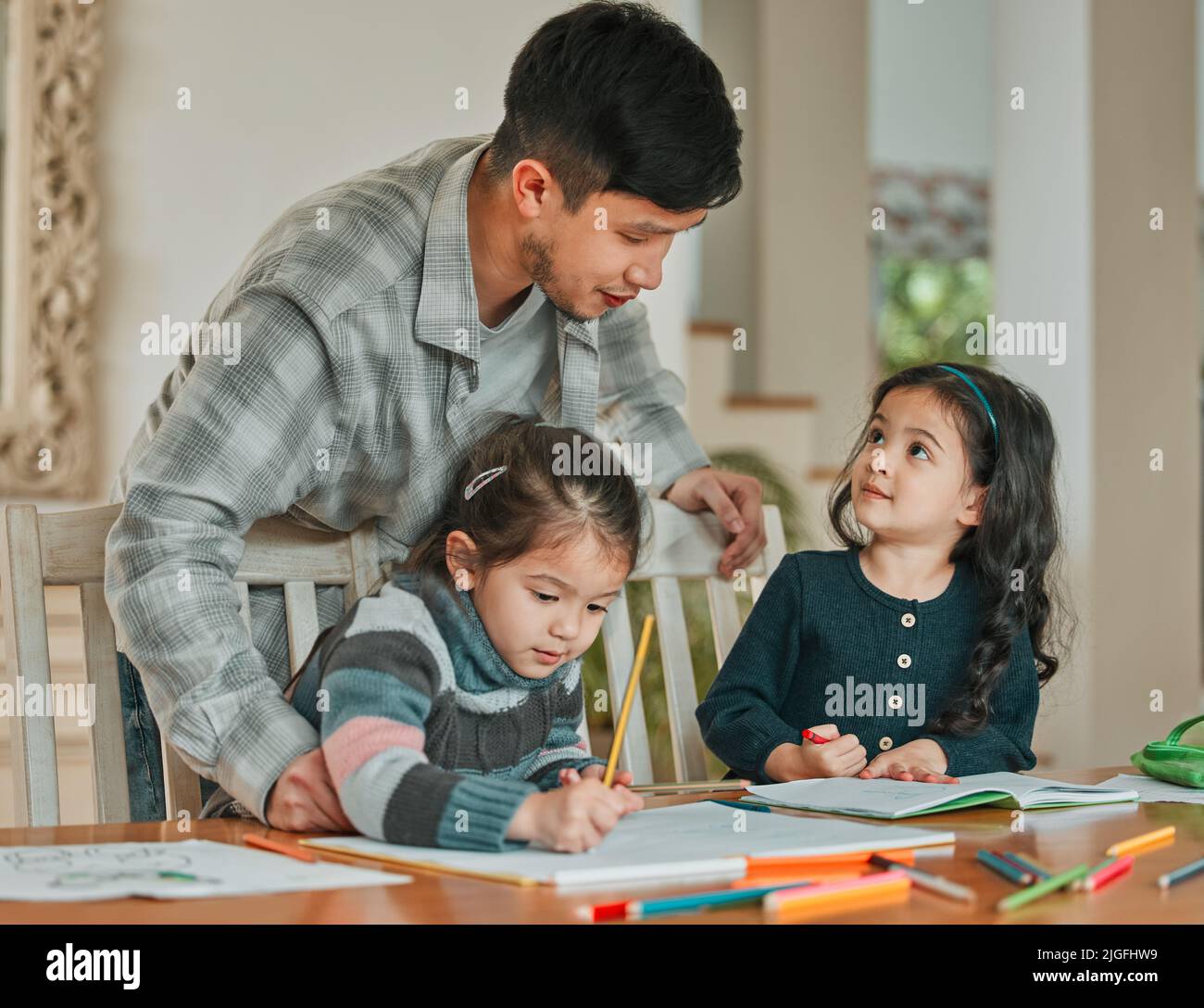 Helping my daughters develop. a young father helping his daughters with ...