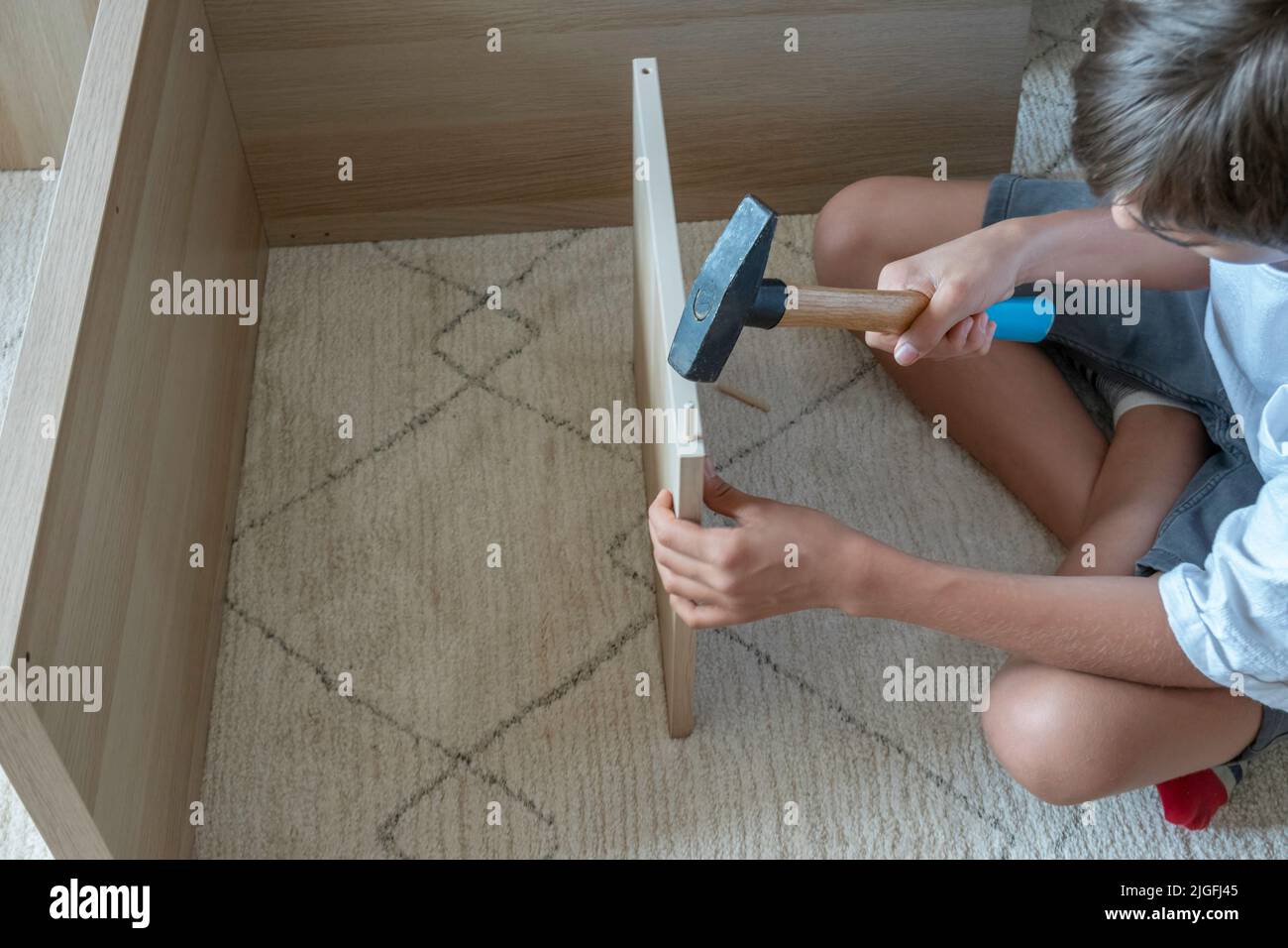 Teenage boy assembling new furniture at home. Home improvement, repair ...