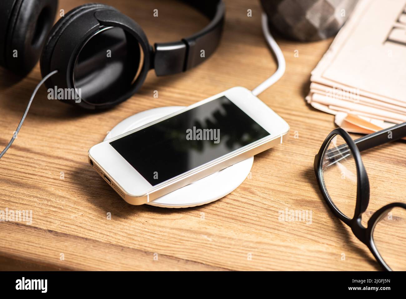 Charging the smartphone with wireless charger on desktop Stock Photo ...