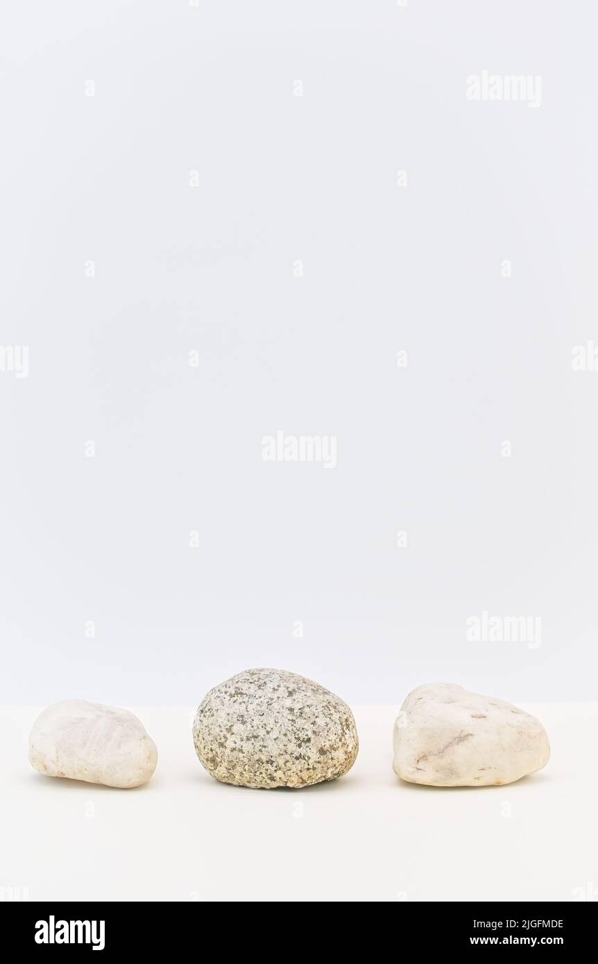 round stones on a white table with space for text Stock Photo - Alamy