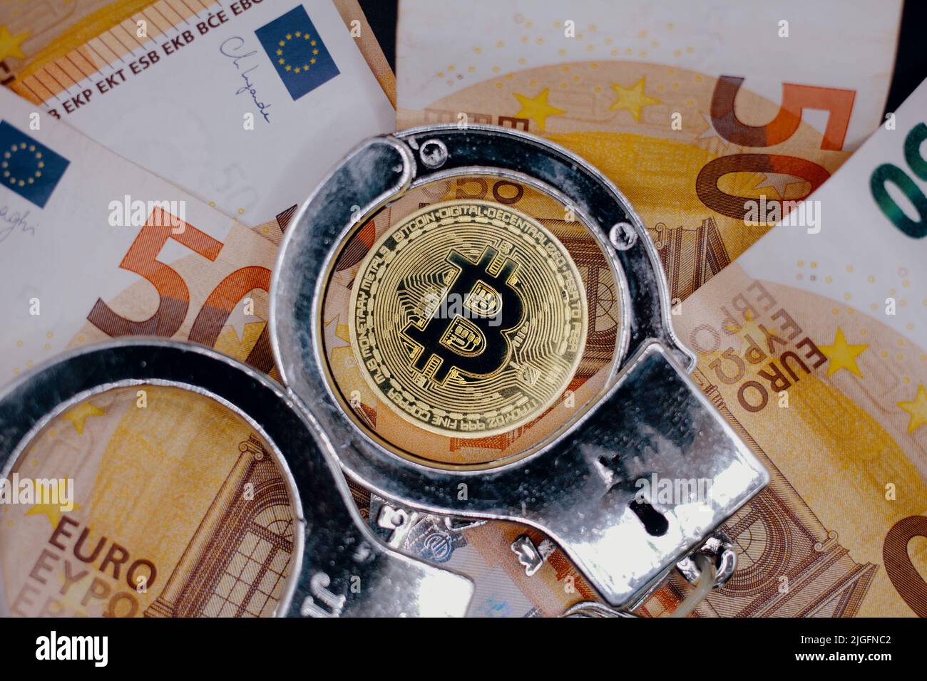 Bitcoin inside handcuffs with European banknotes as background ...