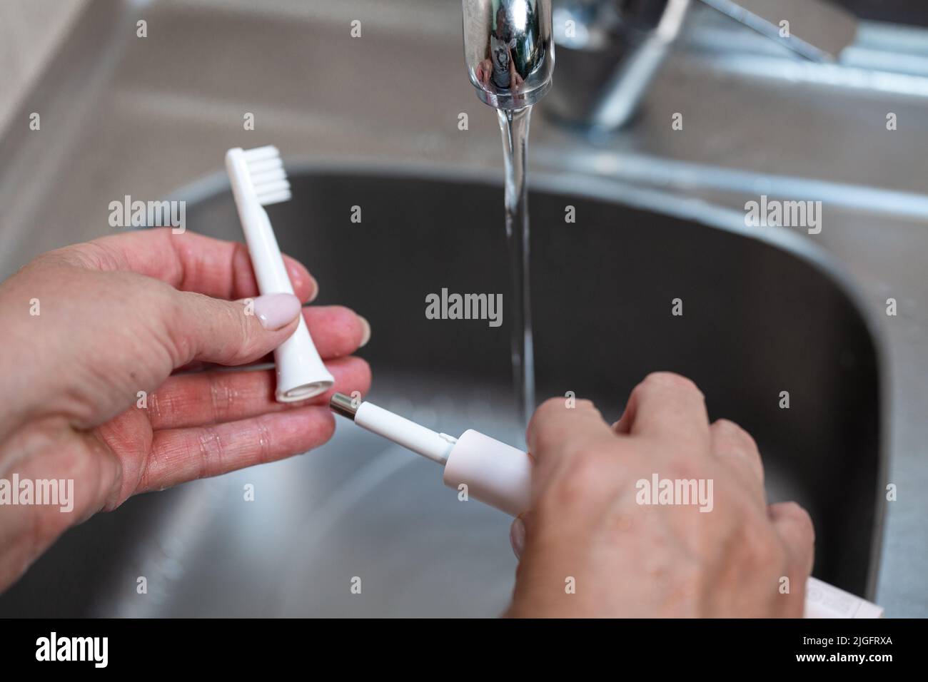 women's hands close up washing a toothbrush Stock Photo - Alamy