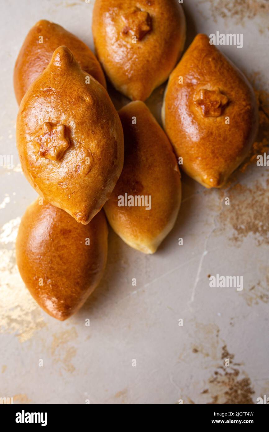 Fried homemade pies with potatoes on the kitchen table. Grandma's ...