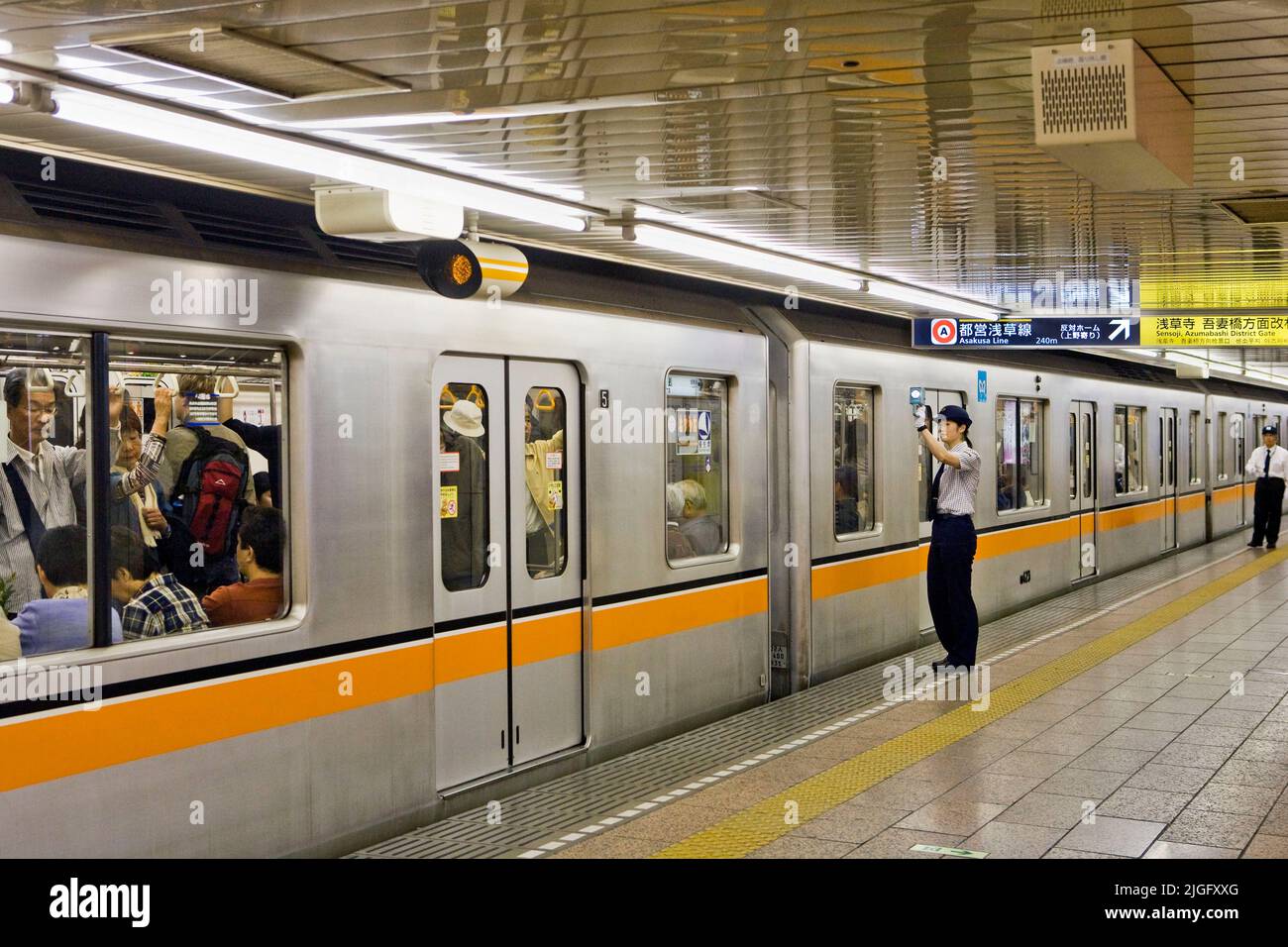 Departing subway train conductor signals Tokyo Japan Stock Photo - Alamy