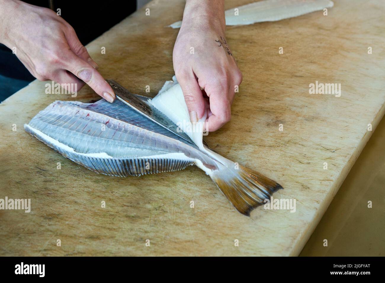 Fisherman fillets halibut hirame in fish market Choshi Chiba Japan ...