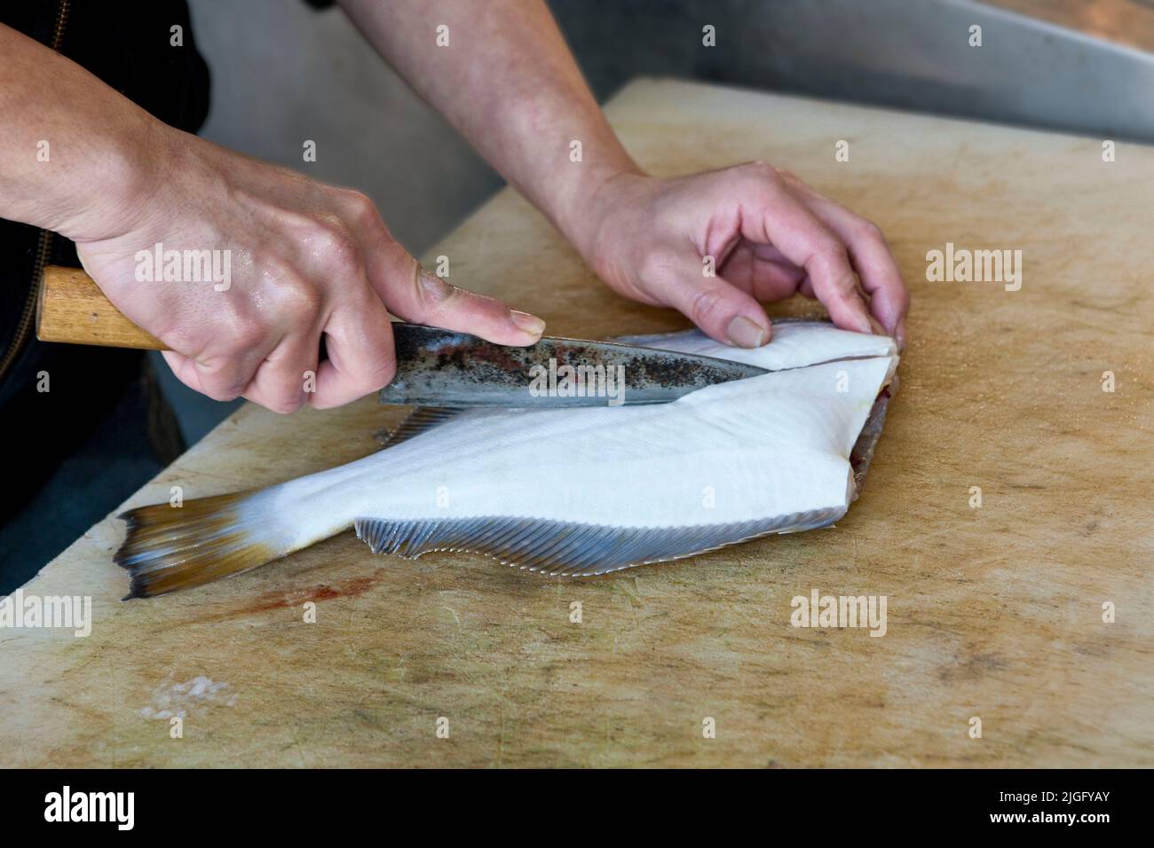 Fisherman fillets halibut hirame in fish market Choshi Chiba Japan ...