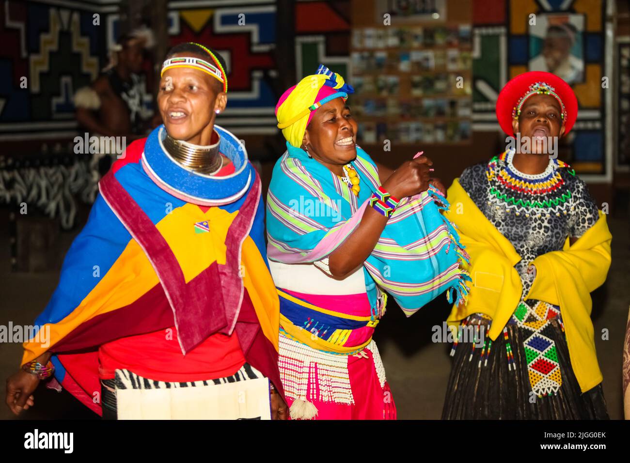 A group of African women performing dance in traditional clothing at an ...