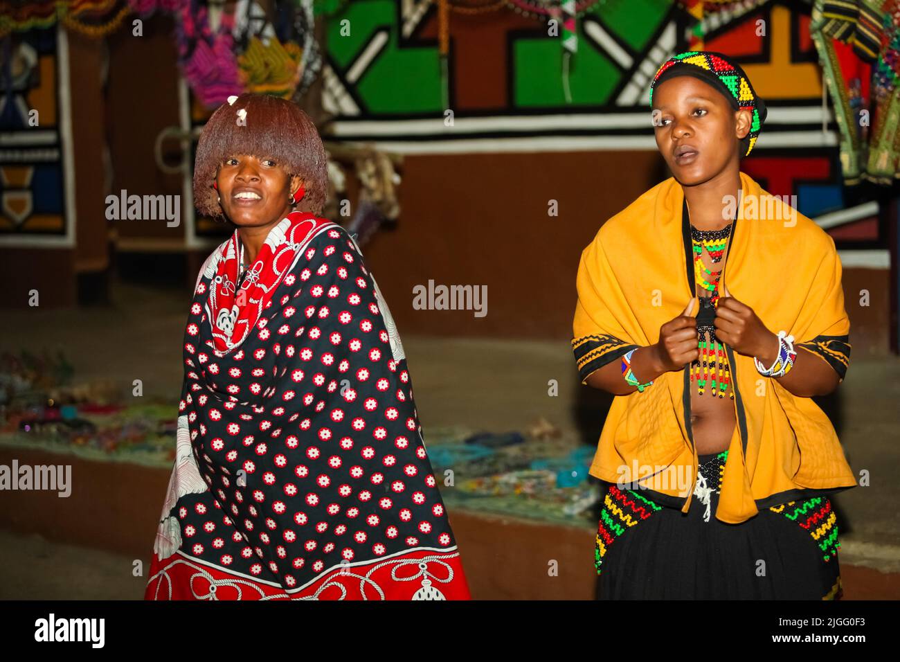 A pair of young African women wearing traditional garb at an event ...