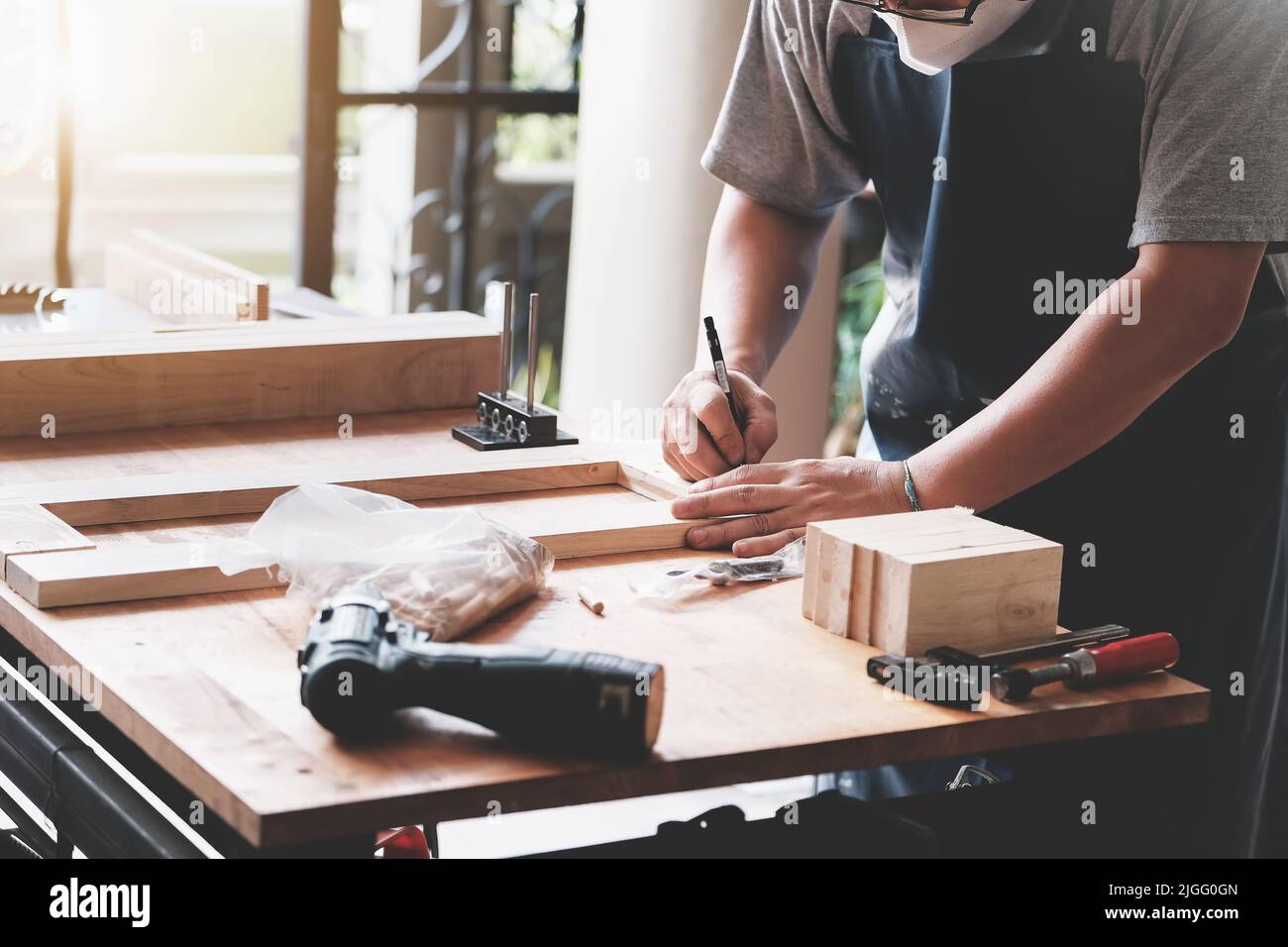 A carpenter measures the planks to assemble the parts, and build a ...