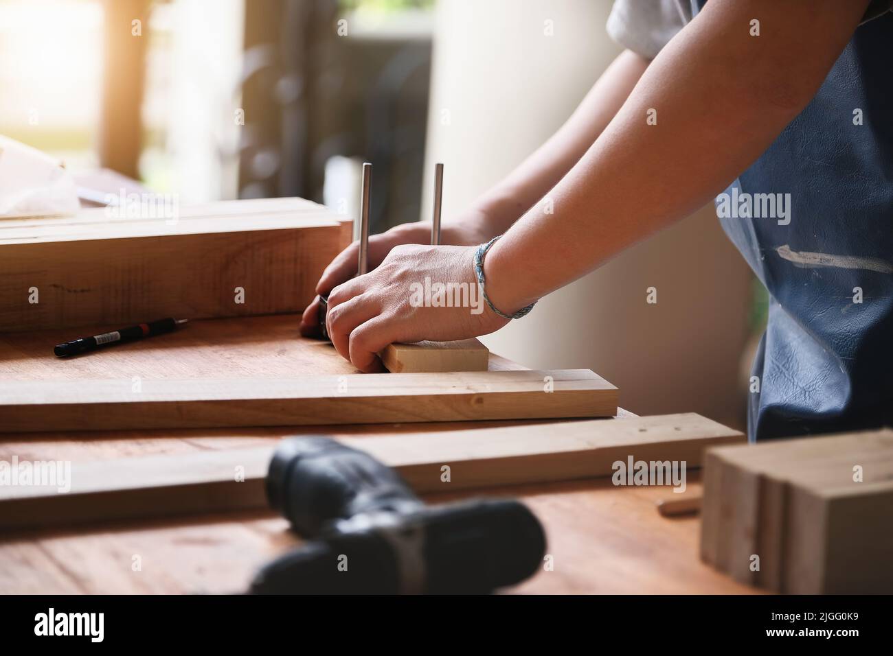 A carpenter measures the planks to assemble the parts, and build a ...