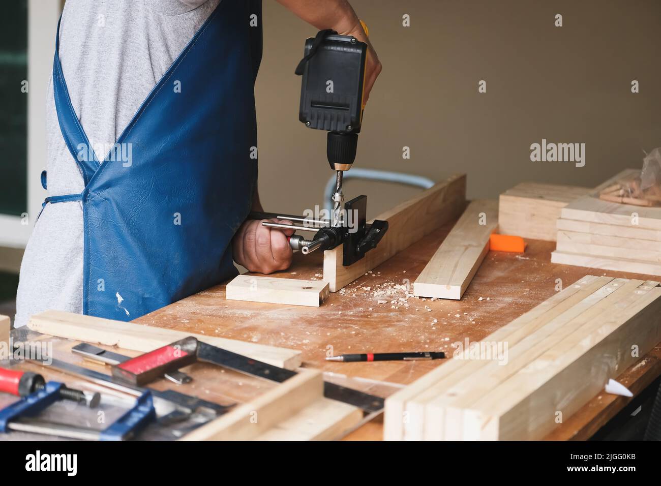 Woodworking entrepreneurs are using a drill through the wood holes to ...