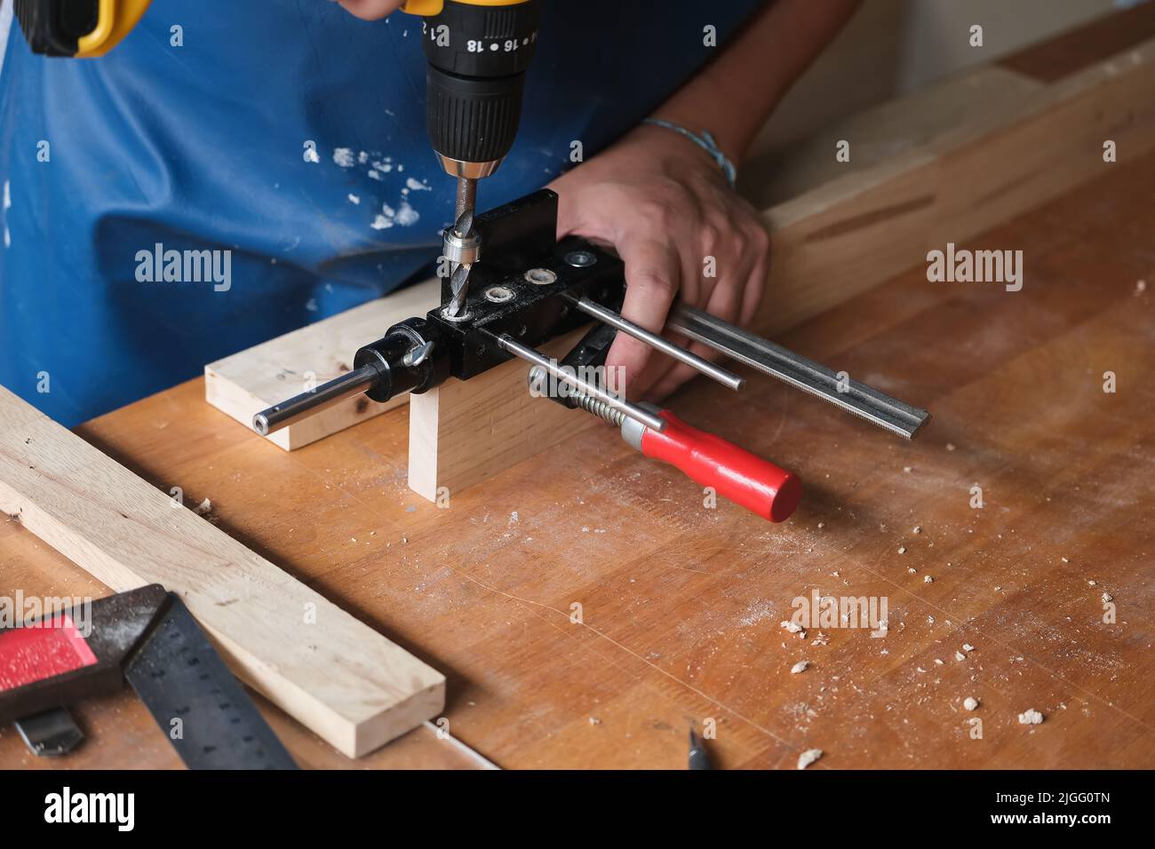 Woodworking entrepreneurs are using a drill through the wood holes to ...