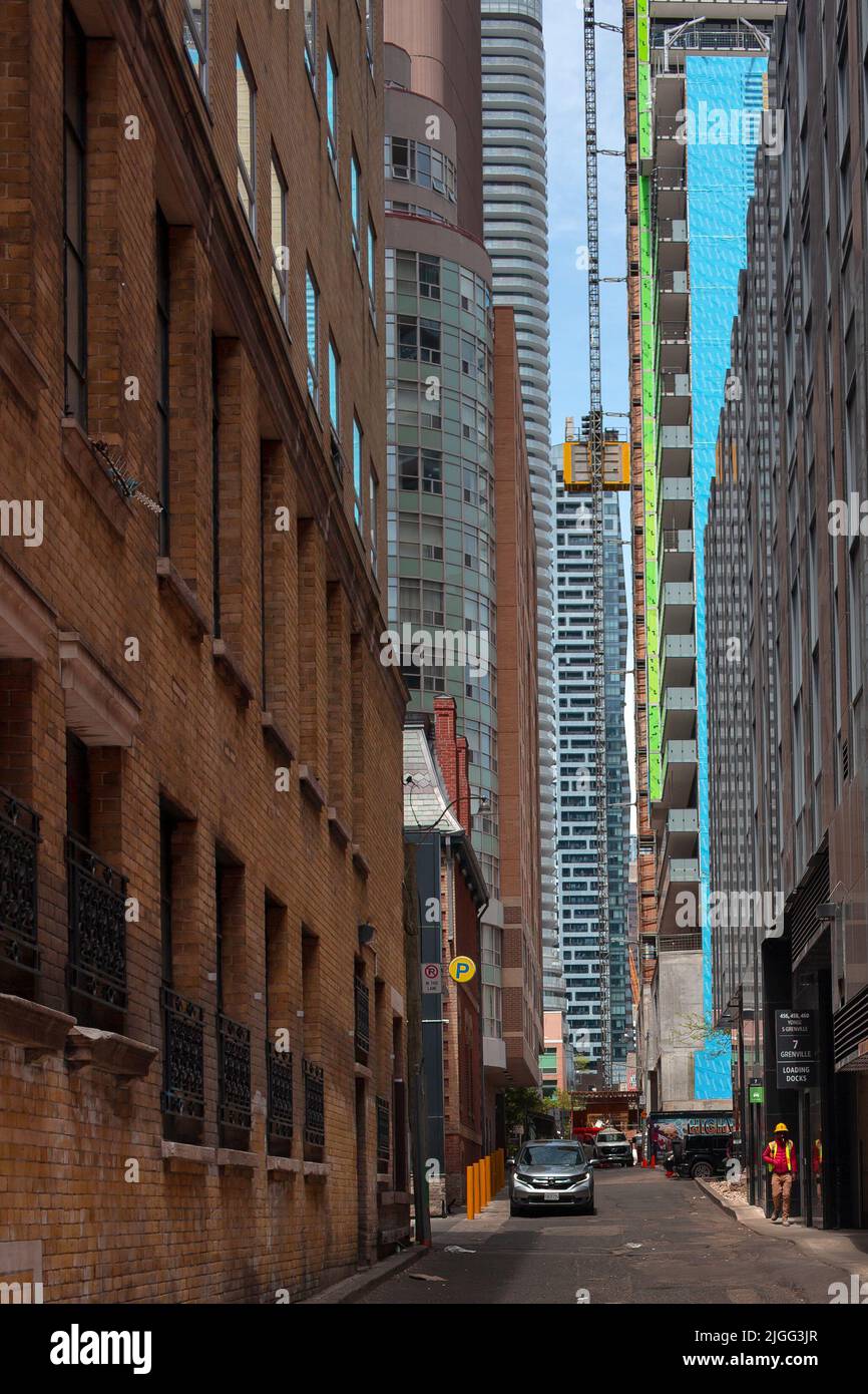Skyscrapers and buildings in Toronto with a construction worker walking ...