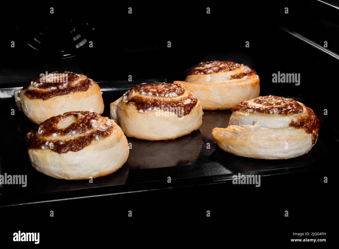 Five cinnamon buns baking and rising in electric oven Stock Photo - Alamy