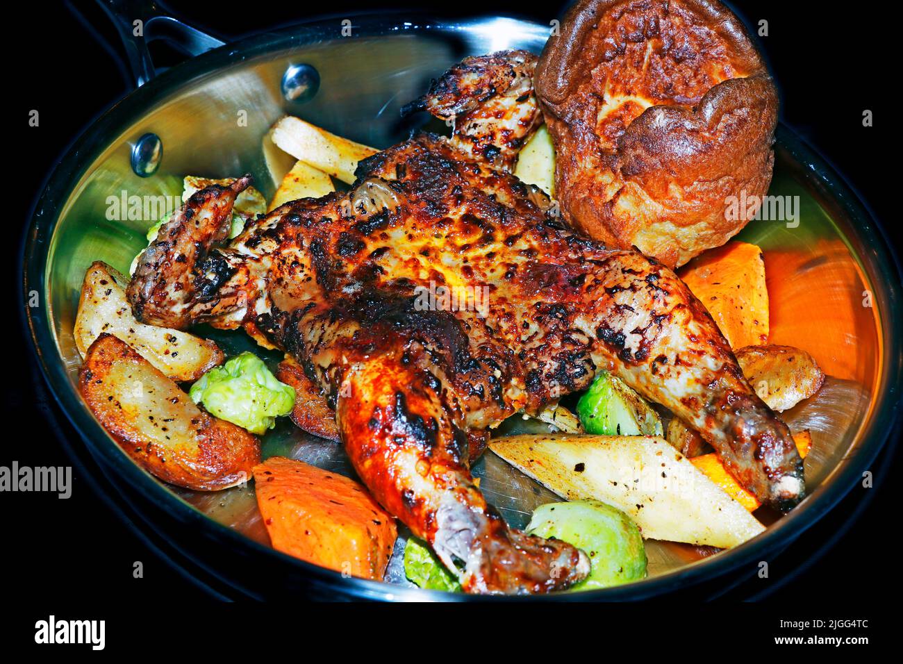 oven roasted spatch cock baby chicken with vegetables in a metal pan ...