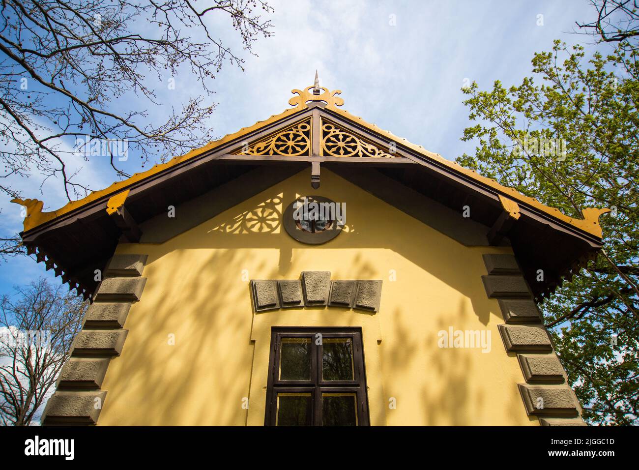 A low angle shot of an old yellow train conductor's house in Hungary ...