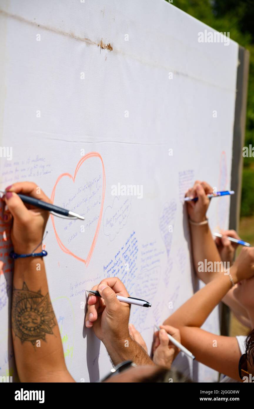 Young people writing their prayers onto a long roll of sheet during ...