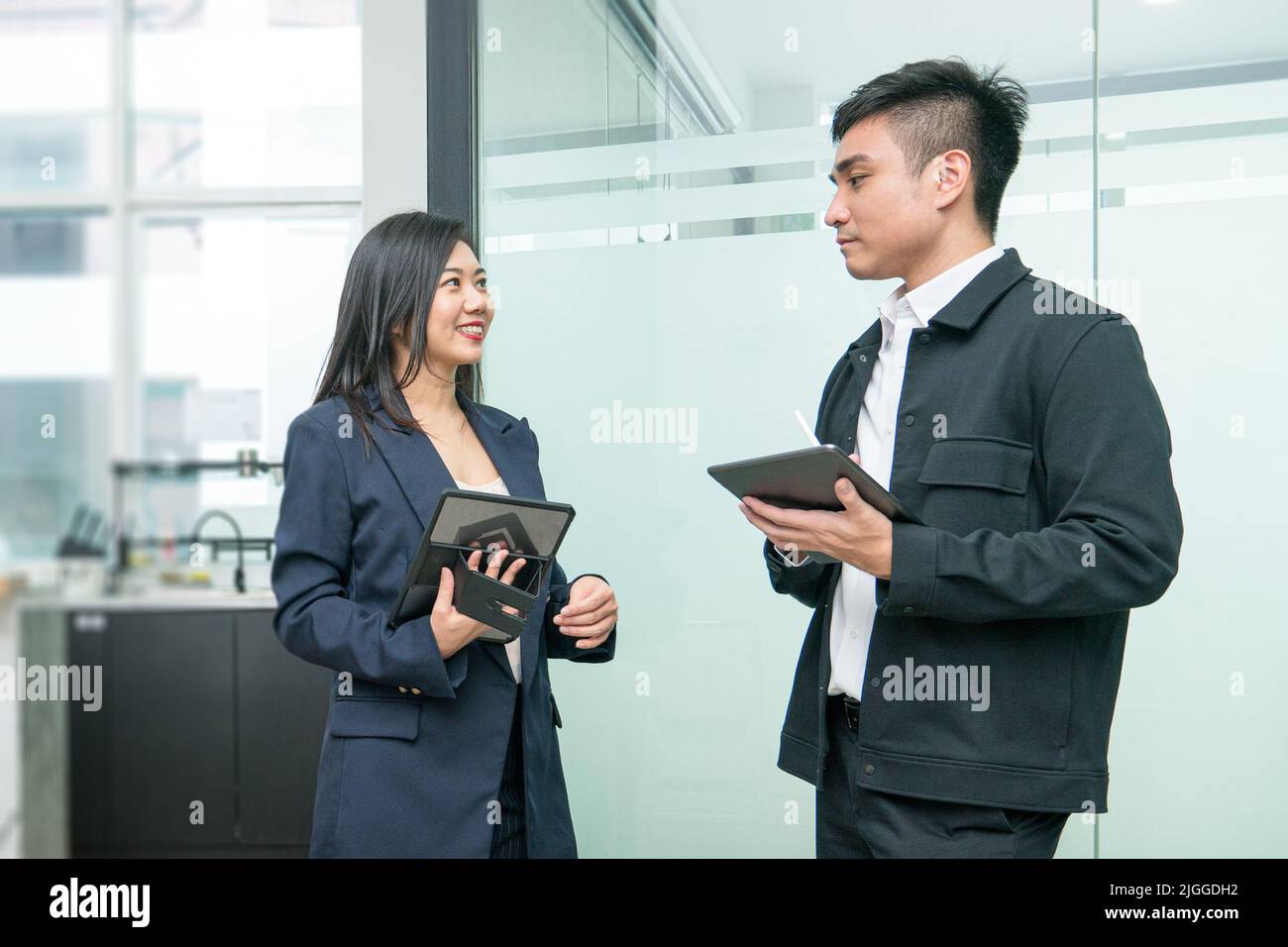 Business people holding digital tablet and talking to each other ...