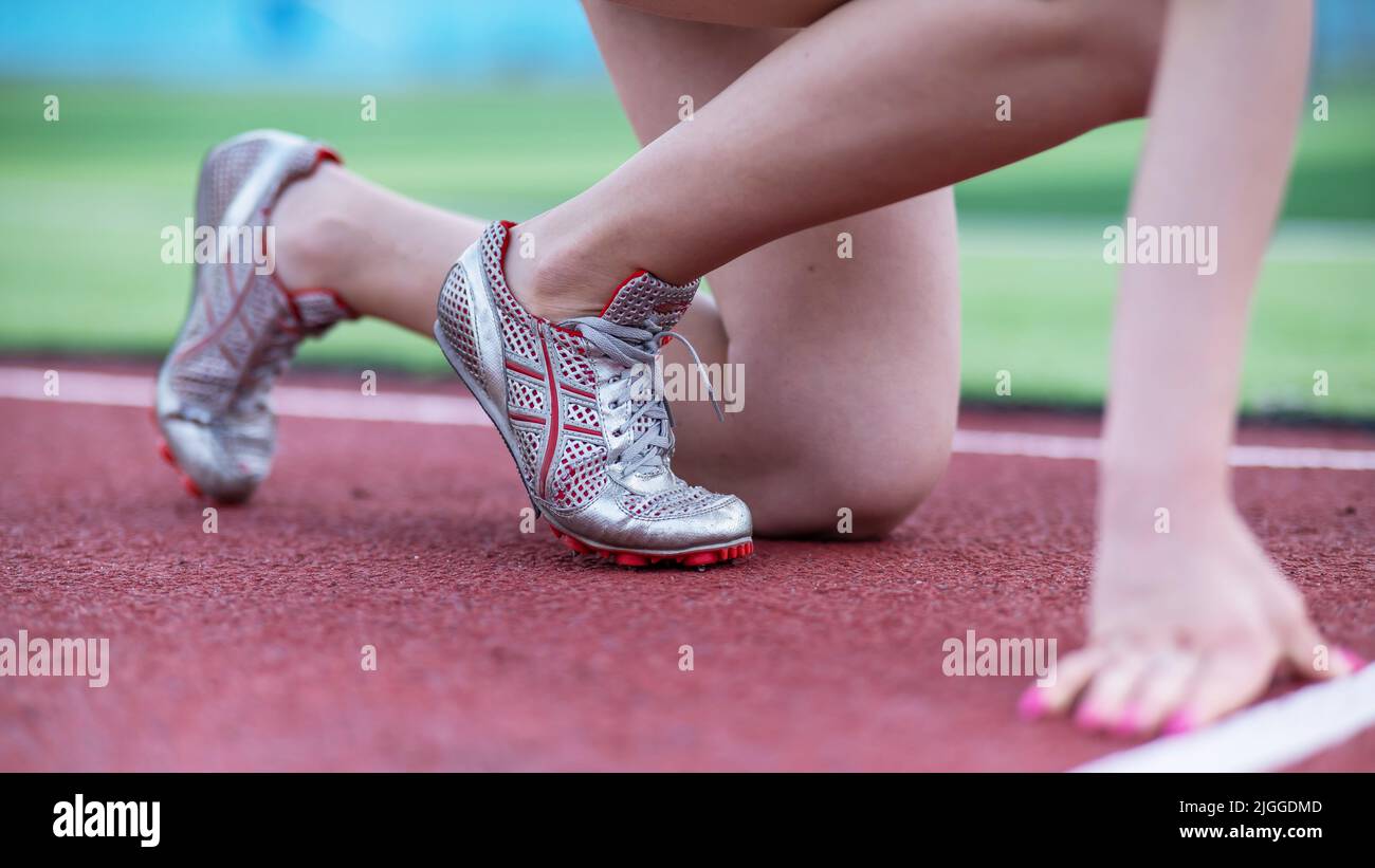 Close-up of female legs. The runner in the stadium is ready for the ...