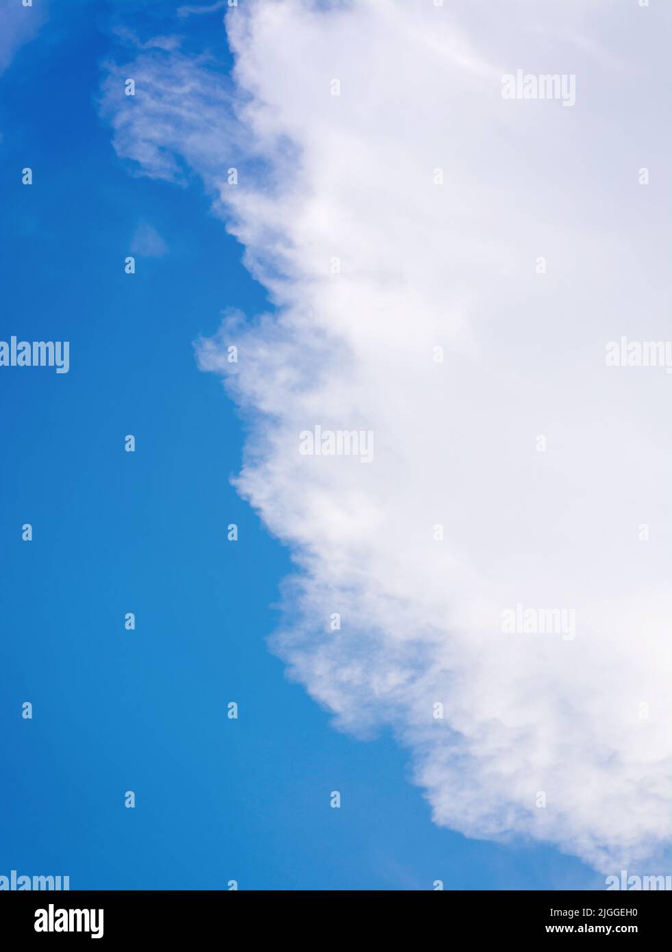 Background with white fluffy cloud on blue sky in vertical format Stock Photo - Alamy